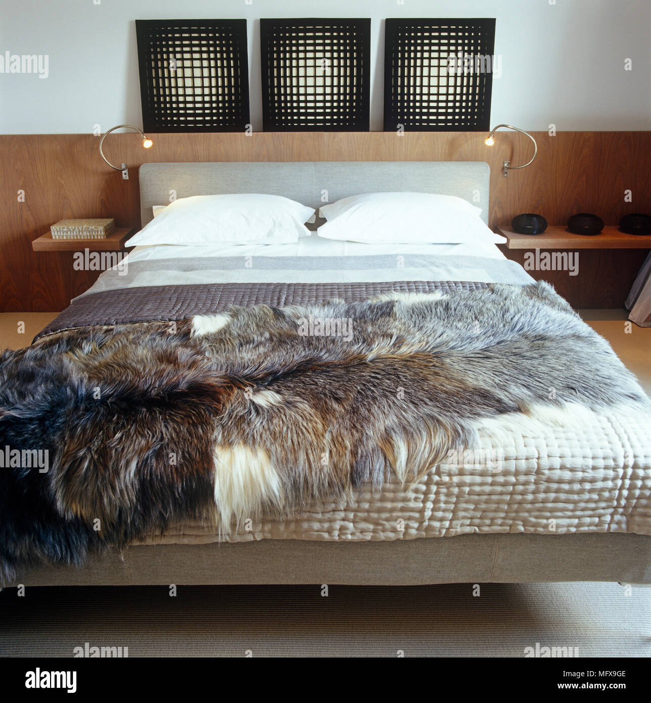 Furry animal skin throw on double bed in modern bedroom Stock Photo - Alamy