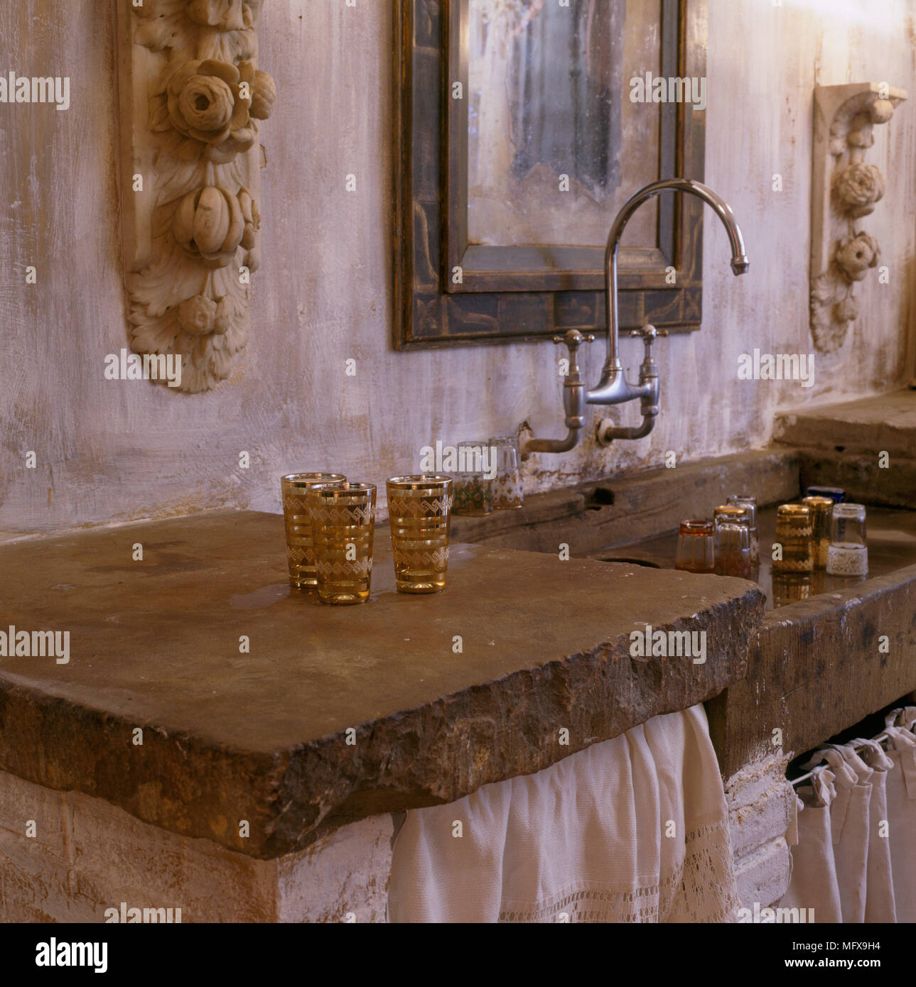 A detail of a rustic, country kitchen showing a solid stone slab work ...