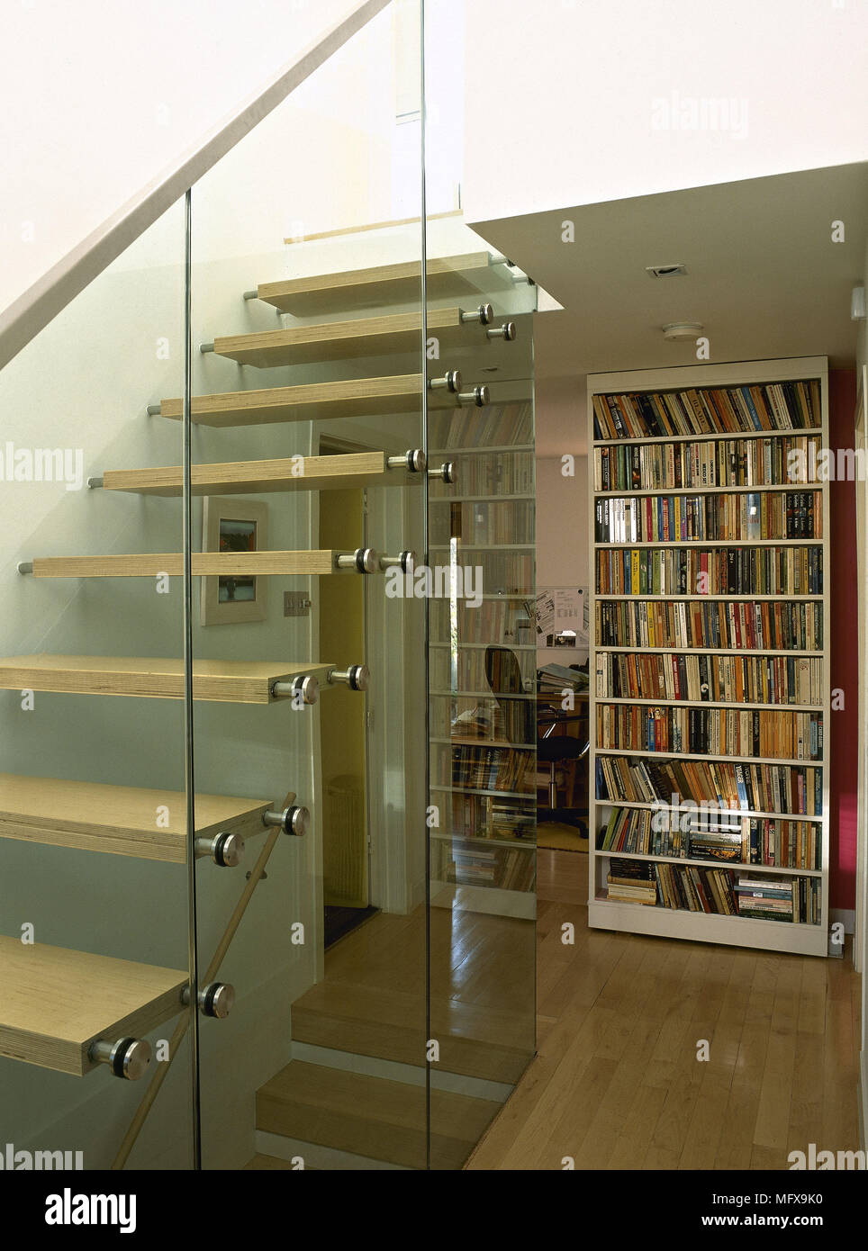 Hallway with bookcase and glass panels on staircase Stock Photo - Alamy