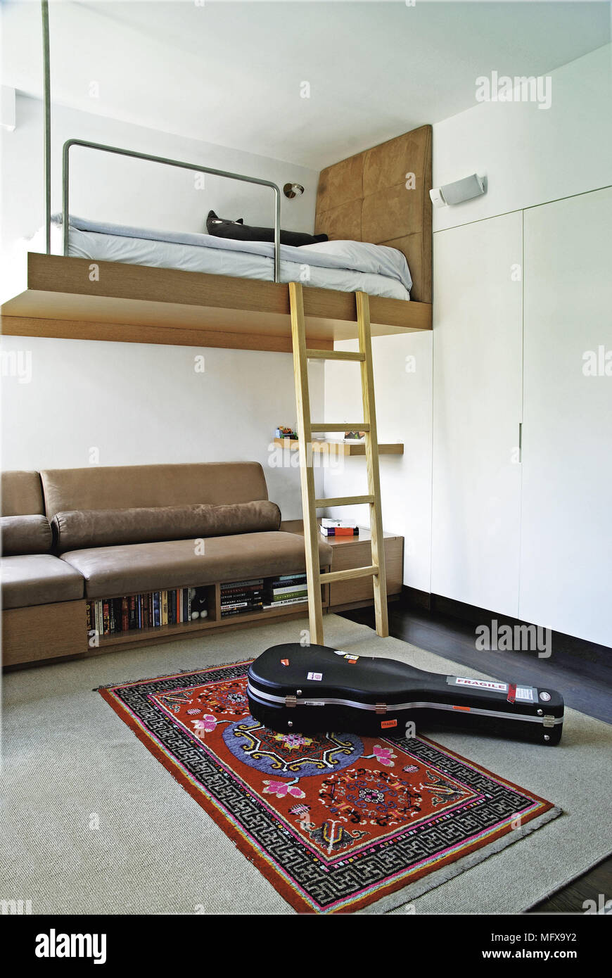 Studio room with bed on elevated platform above seating area Stock ...