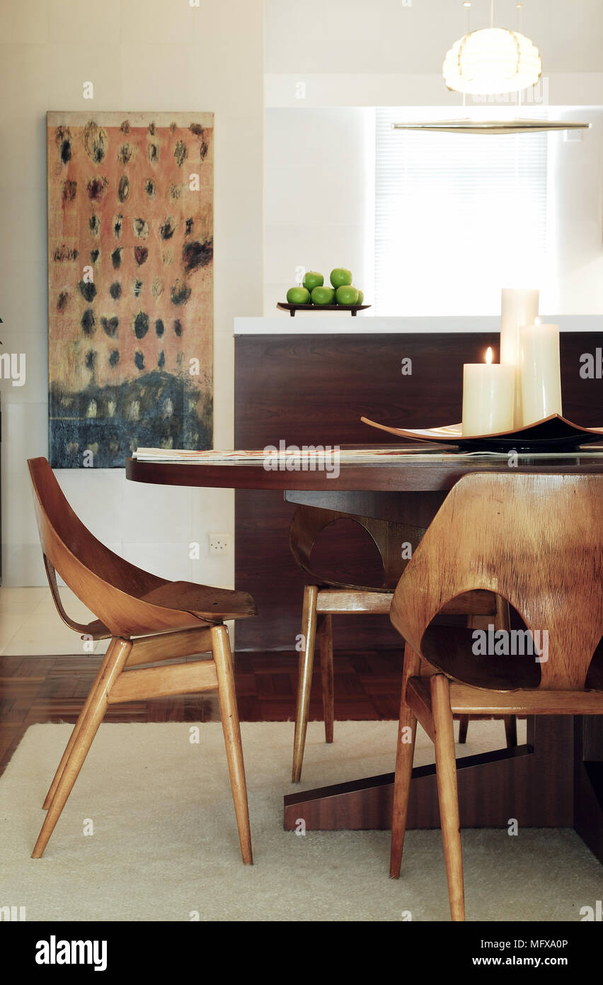 Lit candles on wooden table and chairs in modern dining room Stock ...