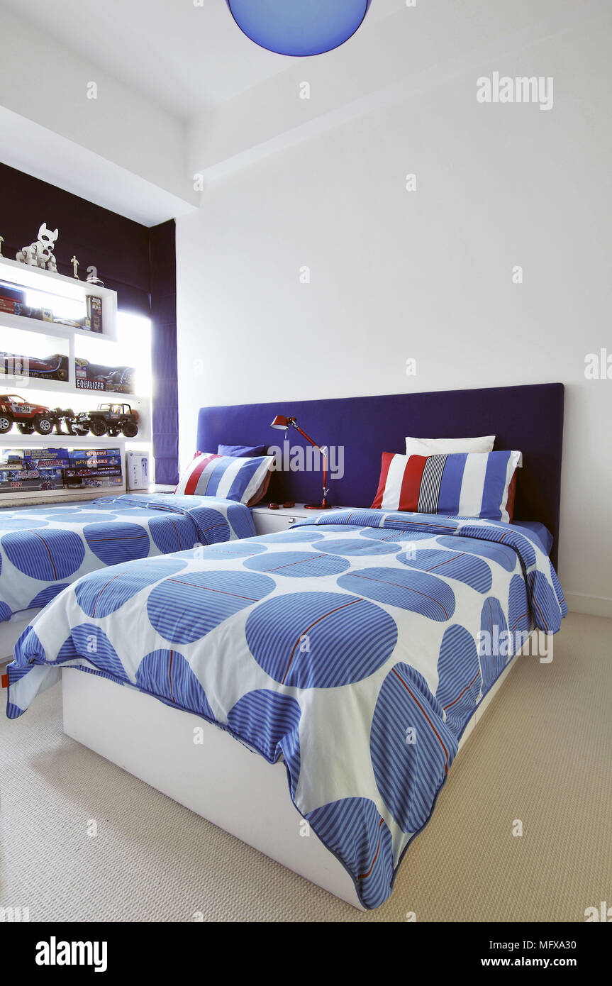 Pair of single beds with blue pattern covers in modern bedroom Stock ...