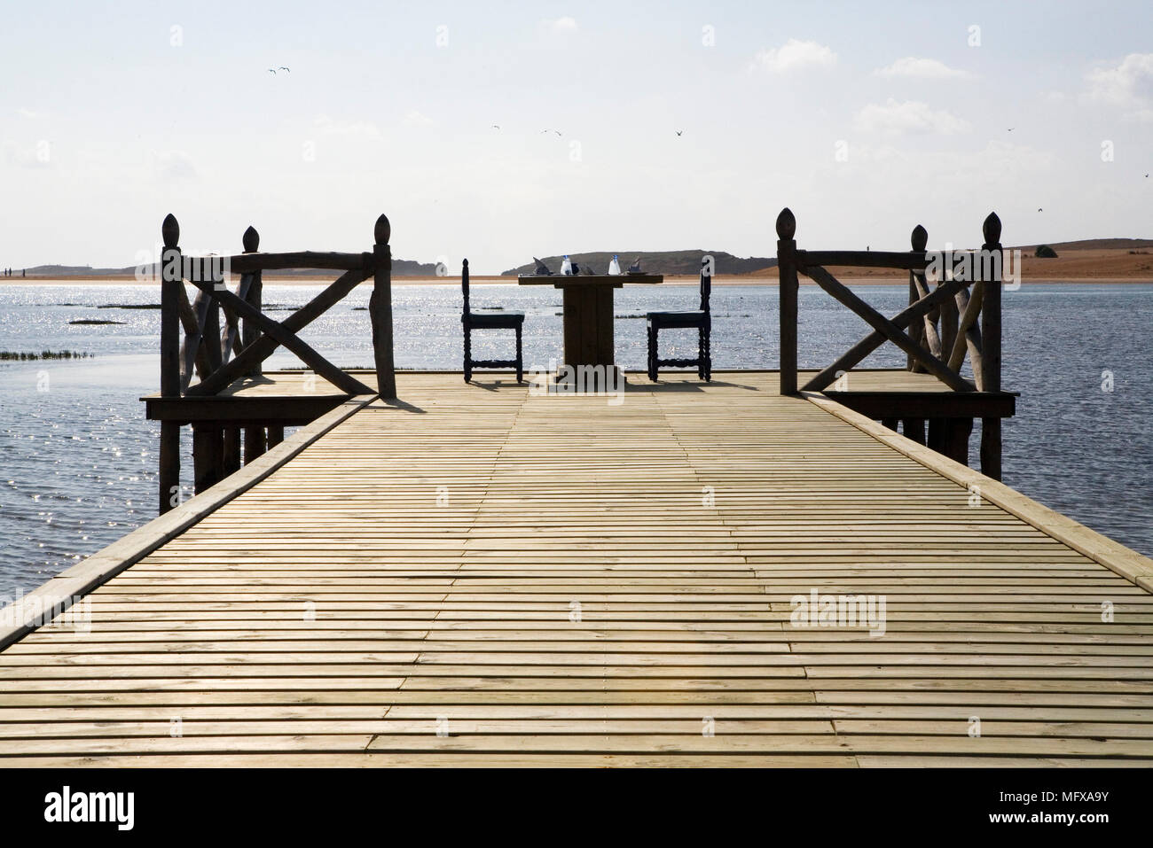 Wooden pier with table and chairs Stock Photo - Alamy