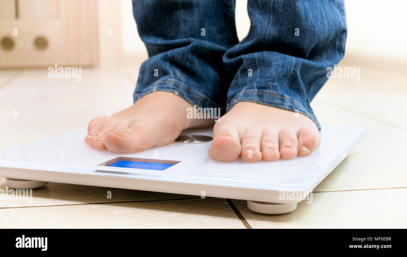 Closeup photo of young woman weighting herself at home Stock Photo - Alamy