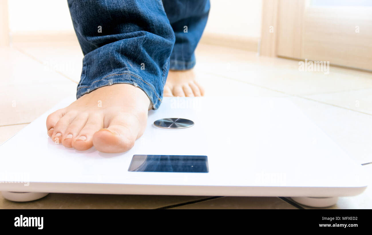 Closeup photo of barefoot person stepping on electronic scales Stock ...