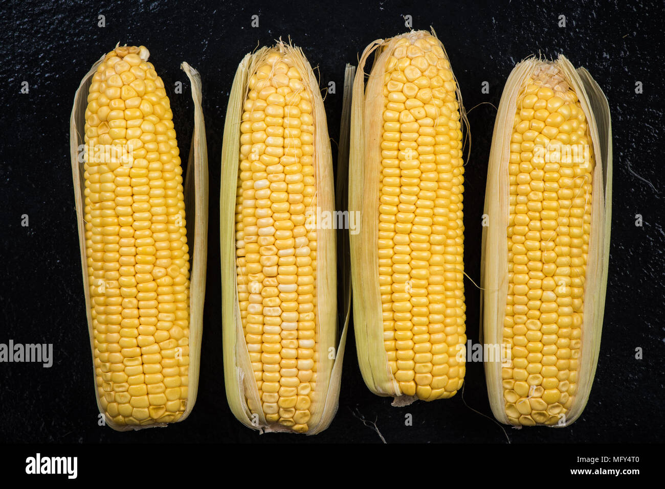 Whole sweetcorn cob on dark background Stock Photo - Alamy
