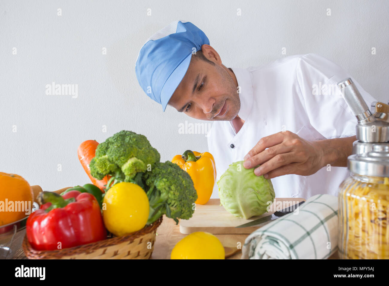 A man of chef In his kitchen checking vegetable and food for his menu ...