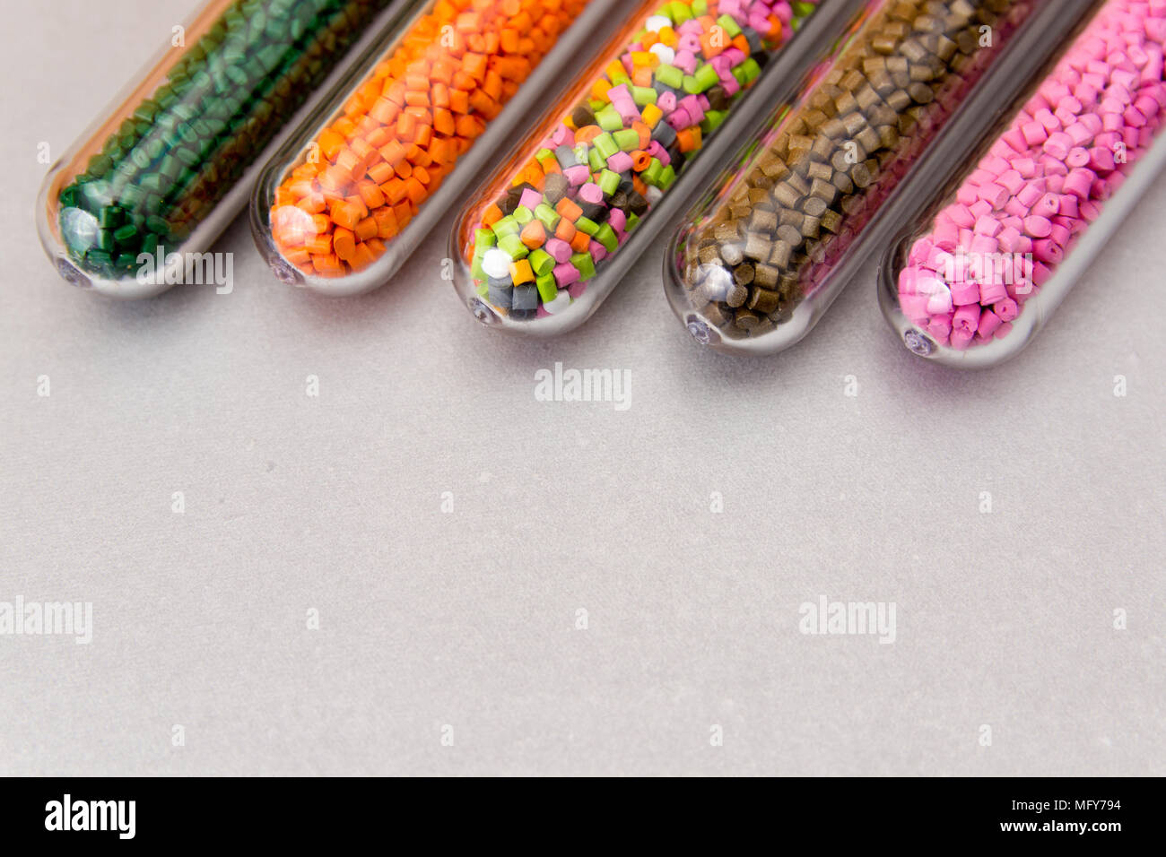 Plastic pellets .Polymeric dye in test tubes on gray background Stock ...