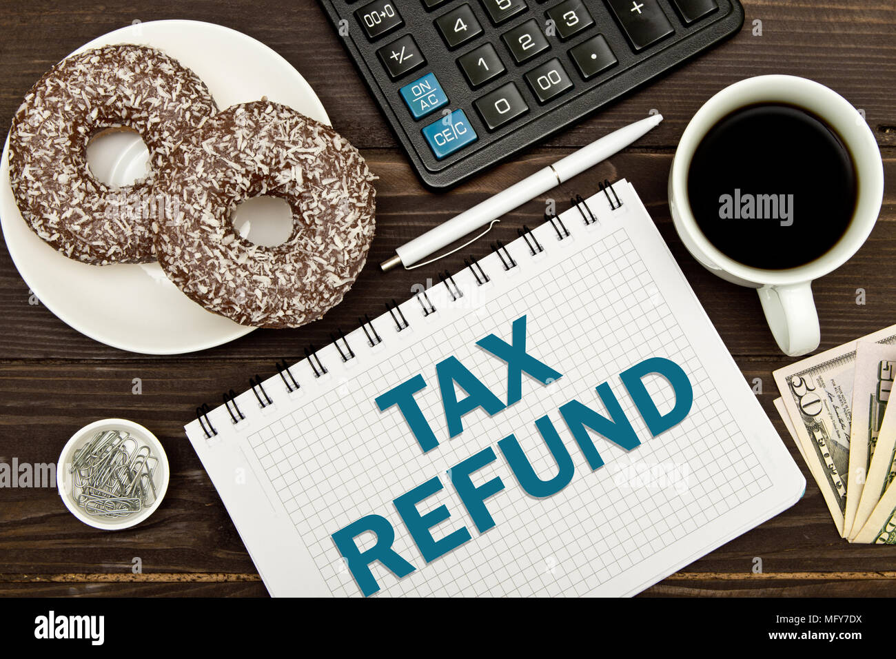 Notebook with a notes TAX REFUND on the office table with coffee and ...