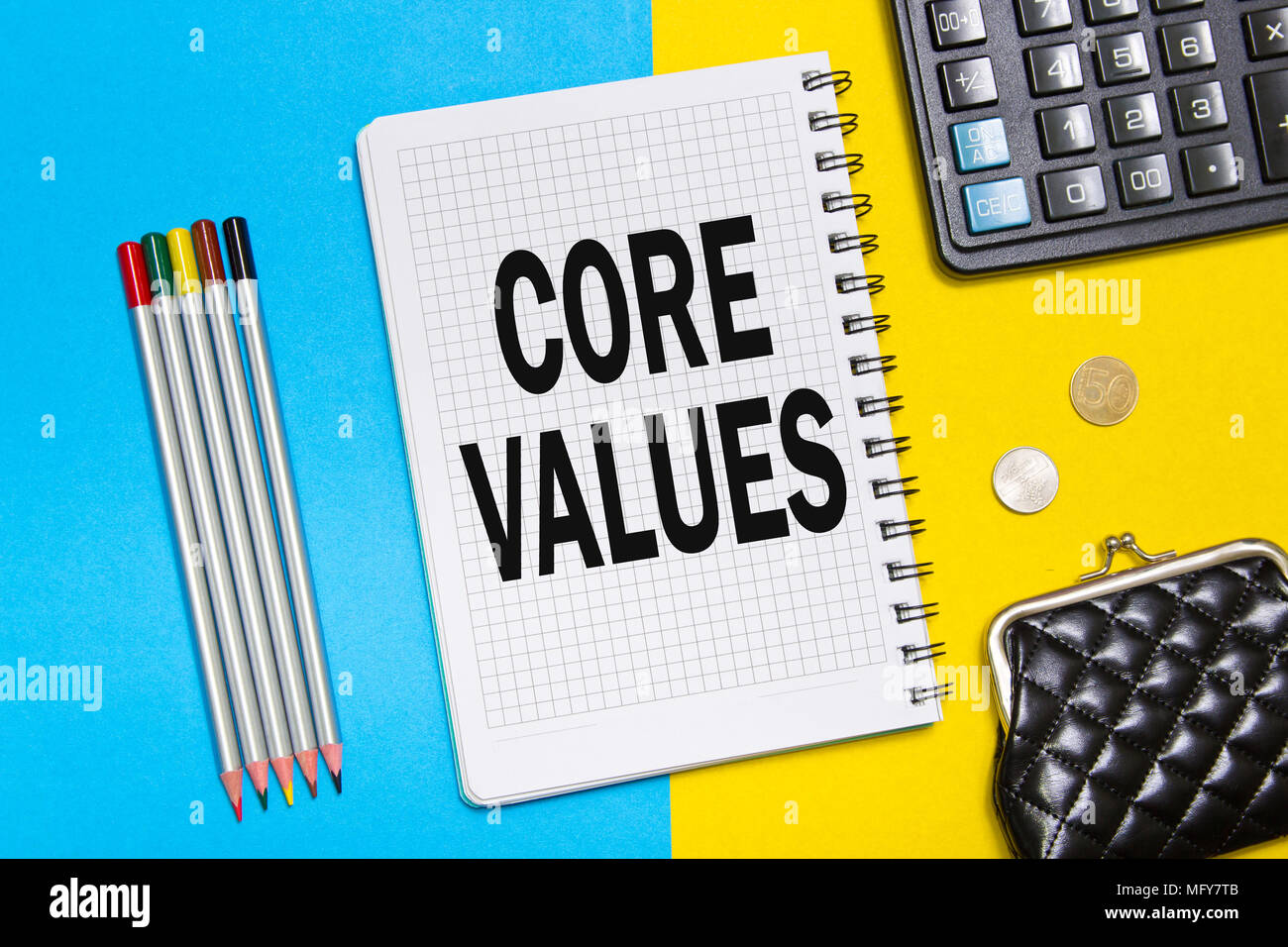 Notebook with notes CORE VALUES with office tools on a blue an yellow ...