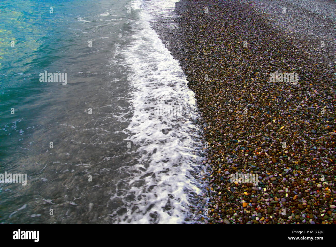 Beach of multi-colored round pebbles, and the splash of salty waves ...