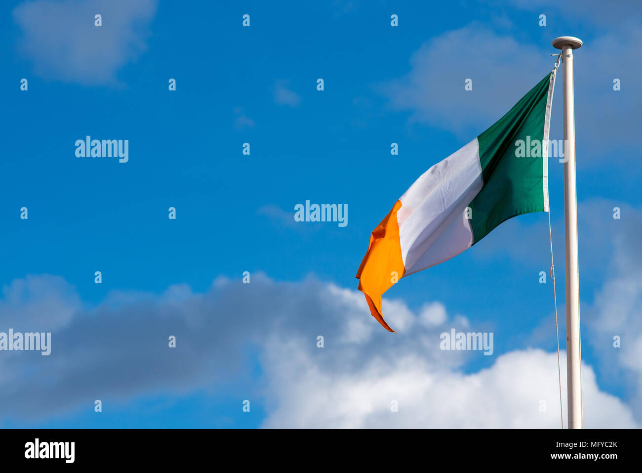 national flag of Ivory Coast blowing in the wind with blue sky in ...