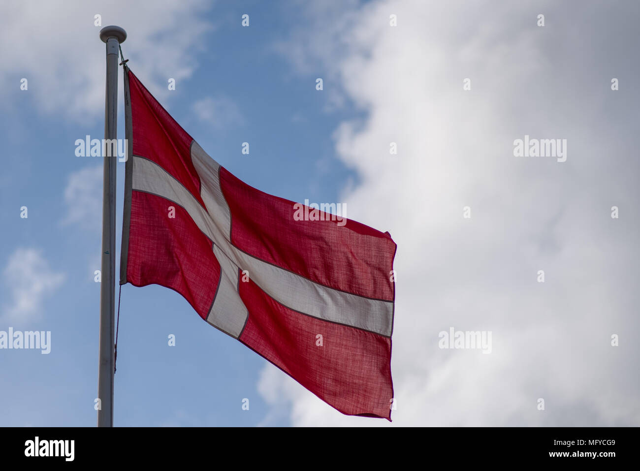 national flag of Denmark blowing in the wind with blue sky and clouds ...