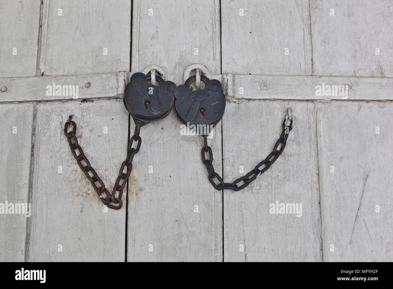 Hand forged twin locks and chains on a barn door in colonial ...
