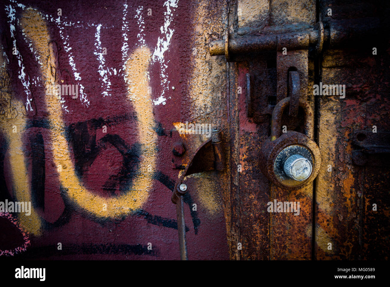 A rusted combination lock on a graffiti-covered metal door Stock Photo ...