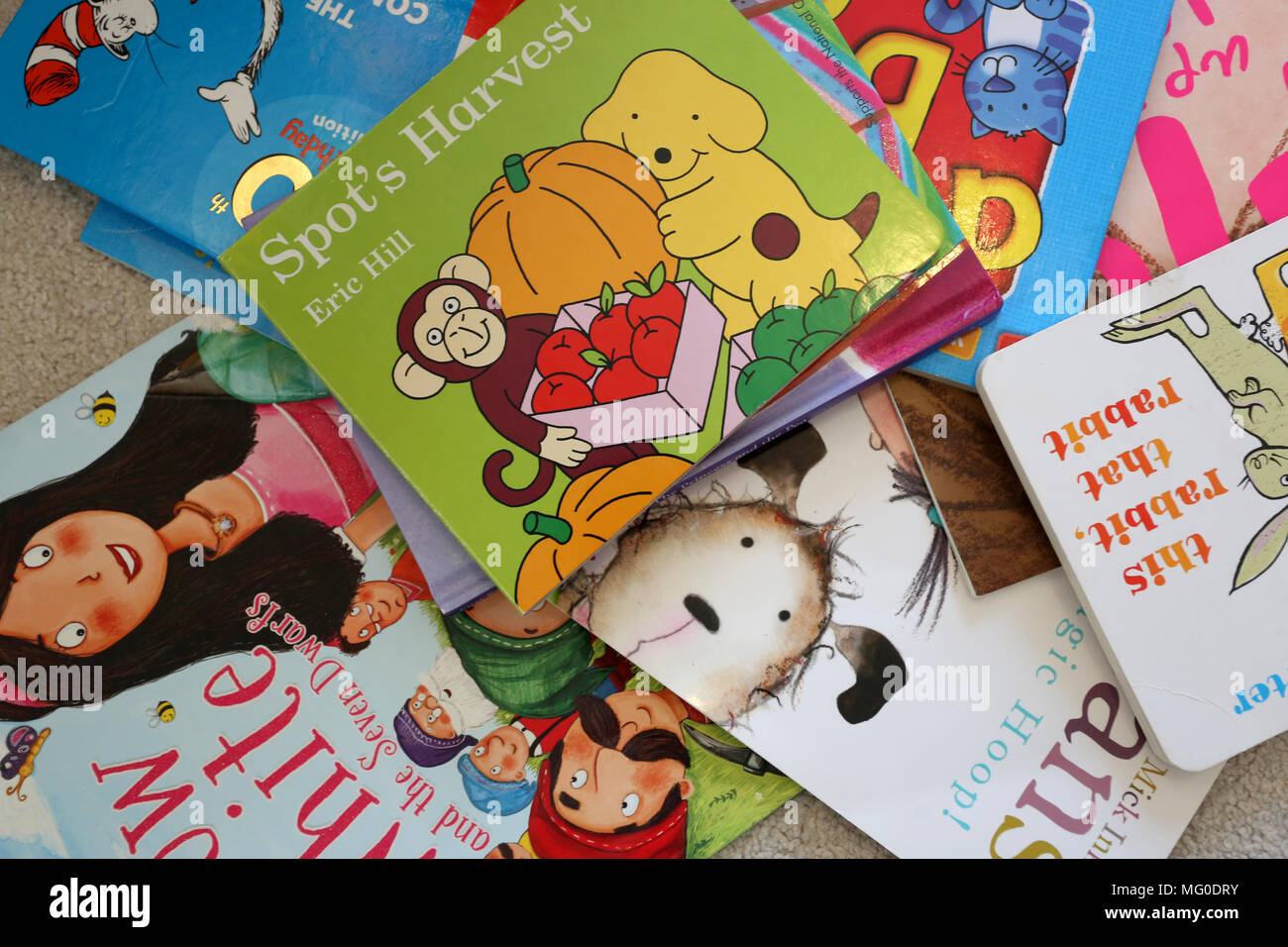 A young girl reading books in her bedroom dressed in cool colourful ...