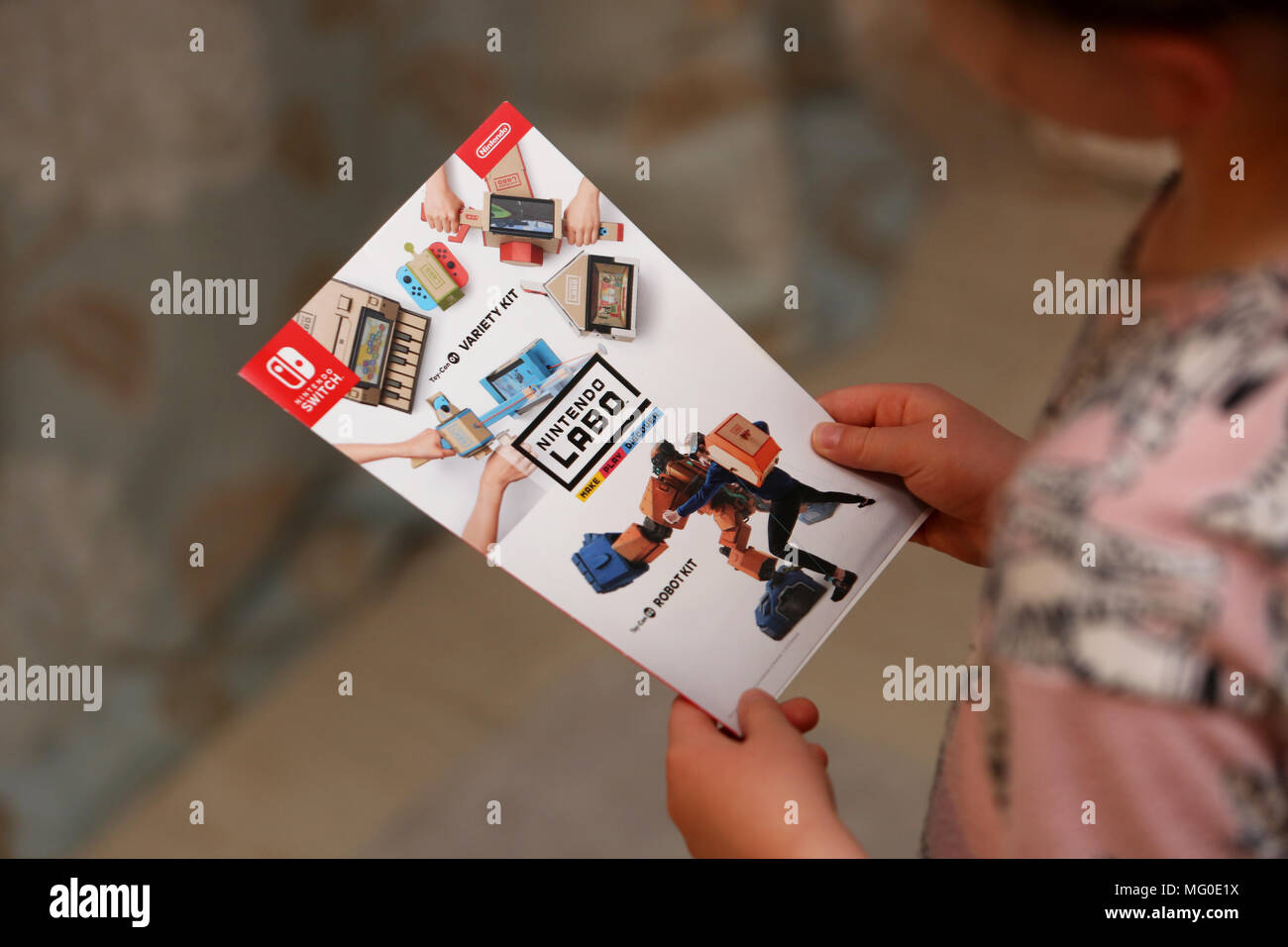 A young girl reading a Nintendo Labo document at her home in London, UK ...