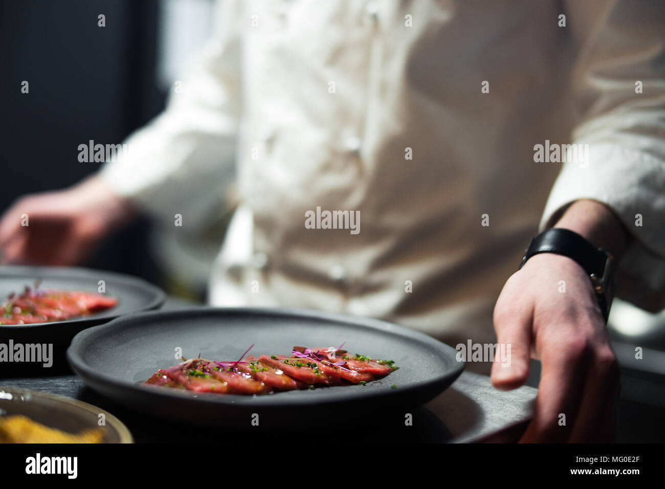 Restaurant Chef cook standing next to grey plate with tuna striped ...