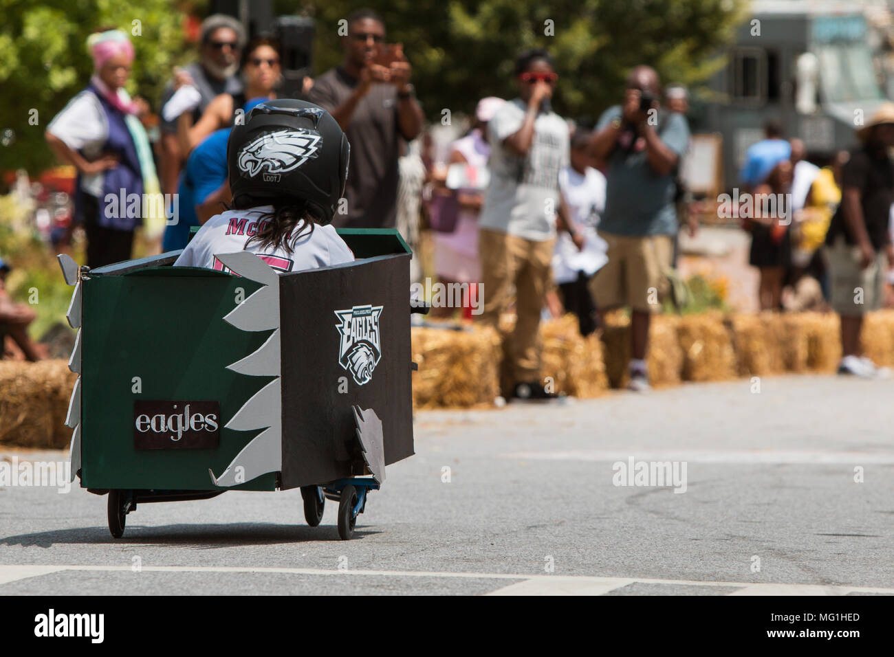A girl steers her homemade car downhill in the Cool Dads Rock Soap Box ...
