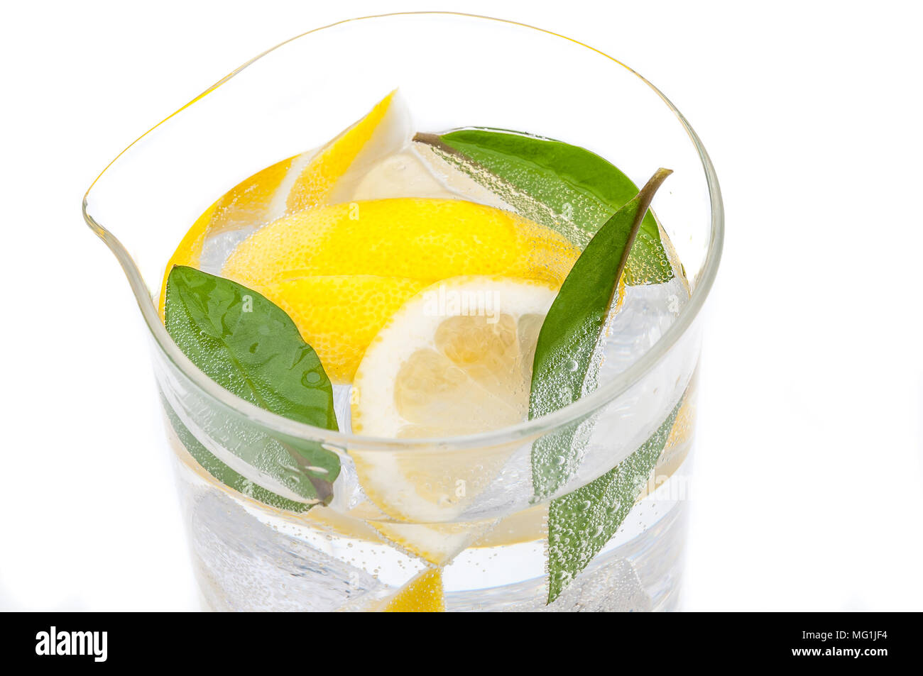 A full jug of drink from ice, lobules of juicy yellow lemon and crystal ...