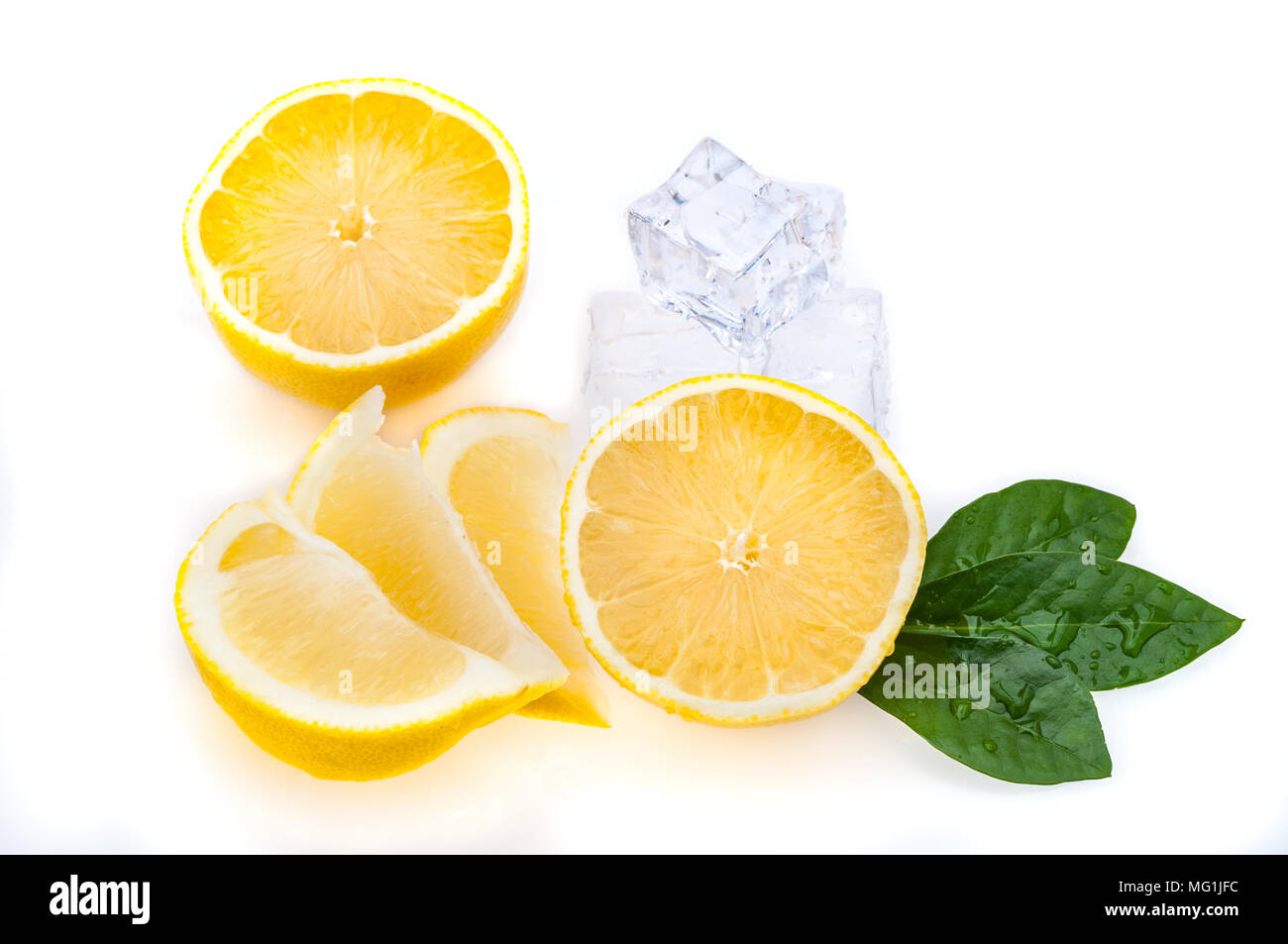 Half a fresh, clean, lemon with green leaves and several cut slices on ...