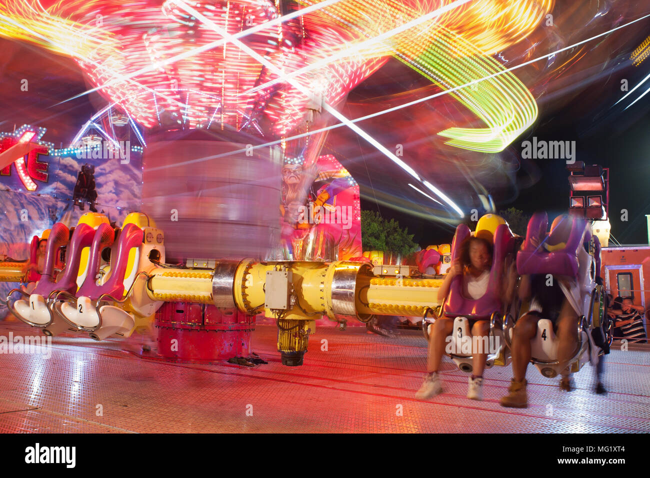 A composite of two images shows motion blur of fast-moving carnival ...