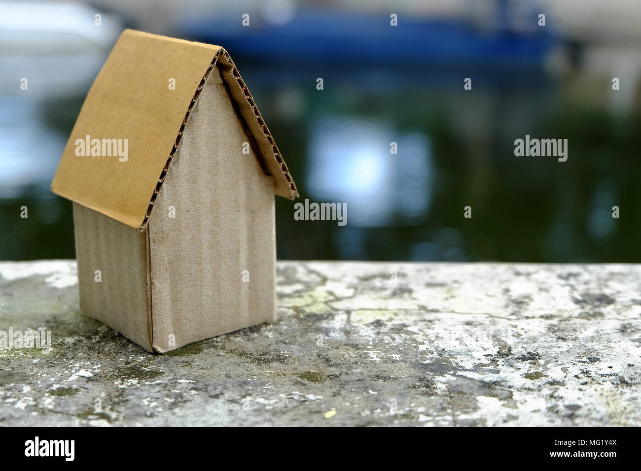 Cardboard House on Concrete Floor with Bokeh Background Stock Photo - Alamy