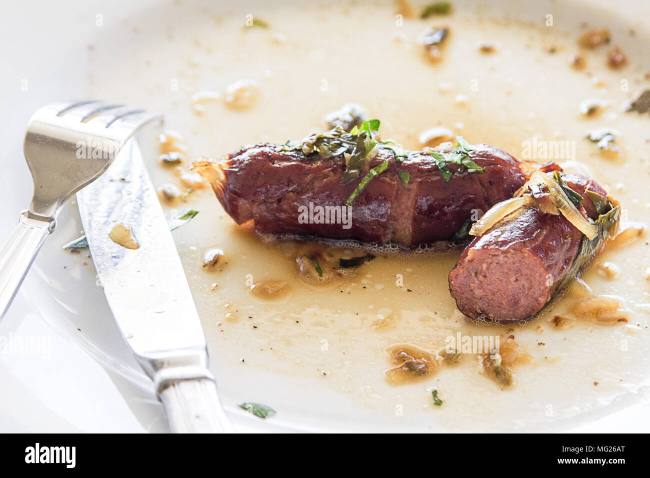 Cooked Sausage cut on a plate, end of meal Stock Photo - Alamy