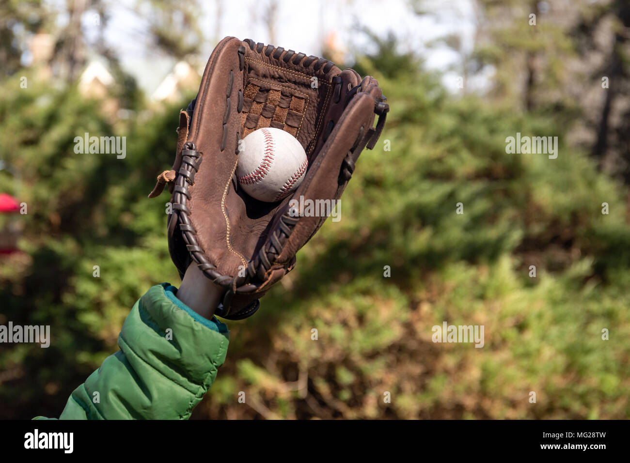 Children hand with baseglove holding baseball ball in blurred ...