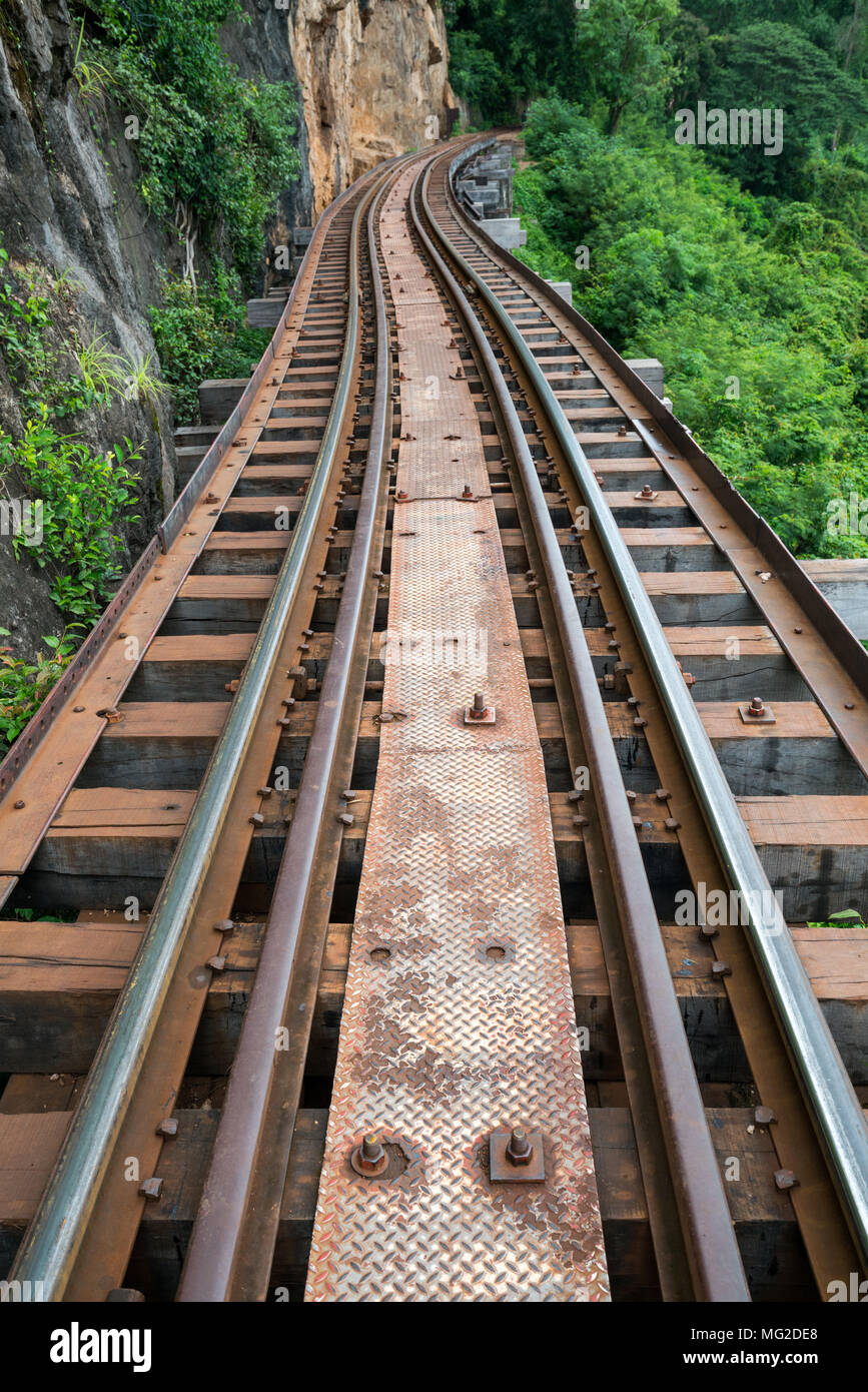Old railroad tracks on bridge beside cliff rock Stock Photo - Alamy