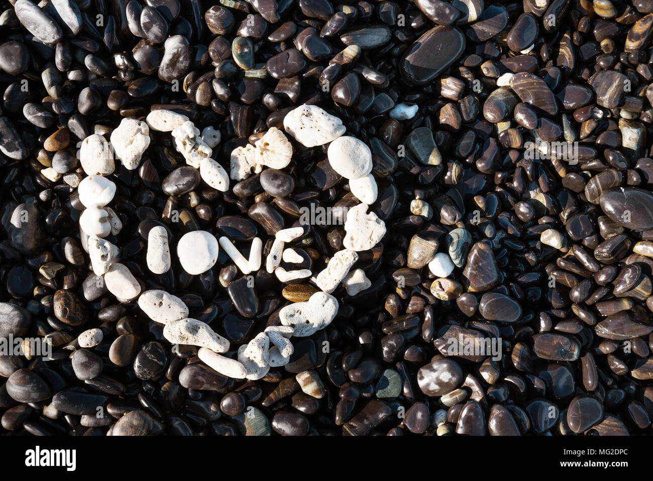 Pebble Stone word love sort on another different color Stock Photo - Alamy