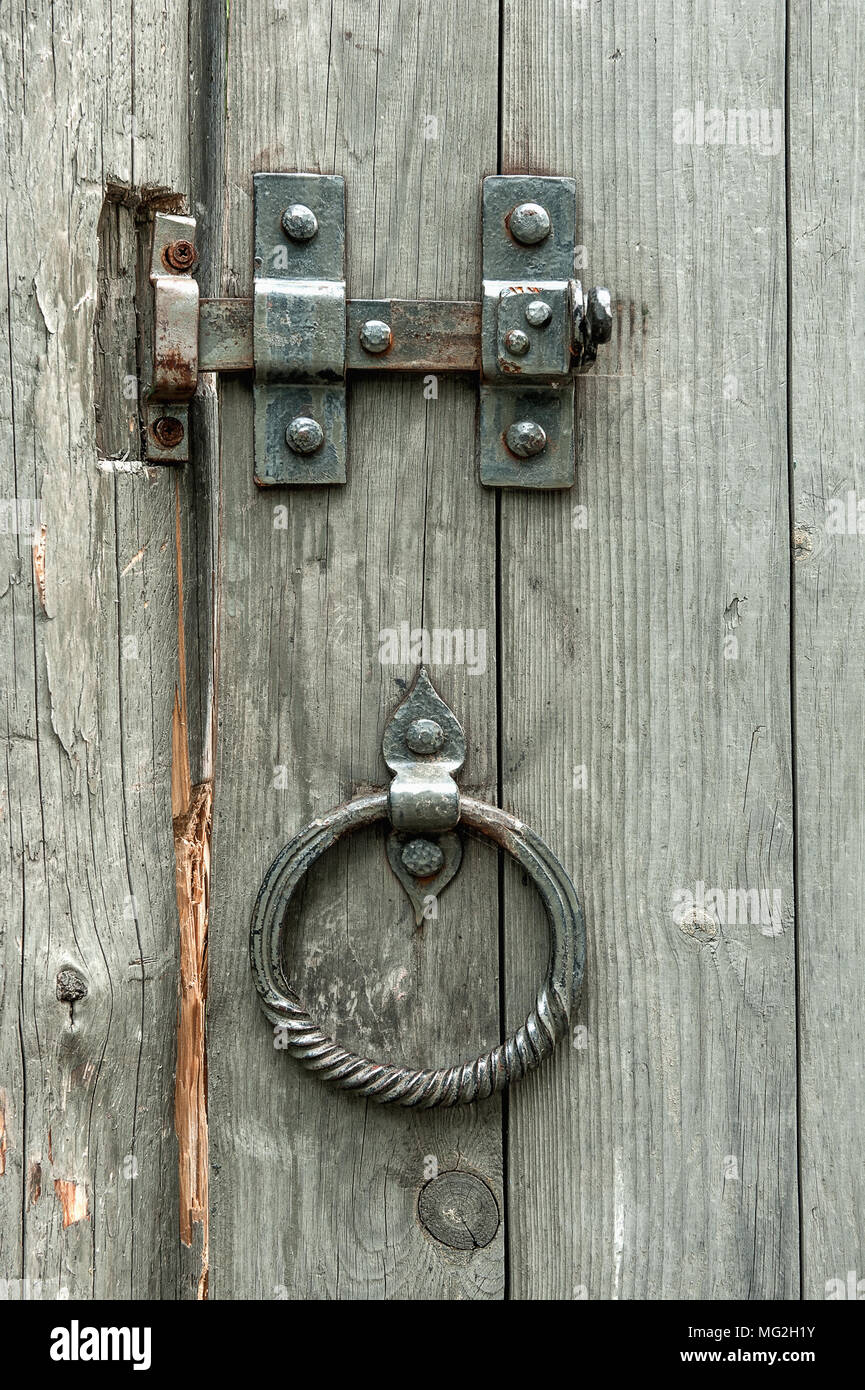 Vintage gate valves and old wooden gates with round metal handles in ...
