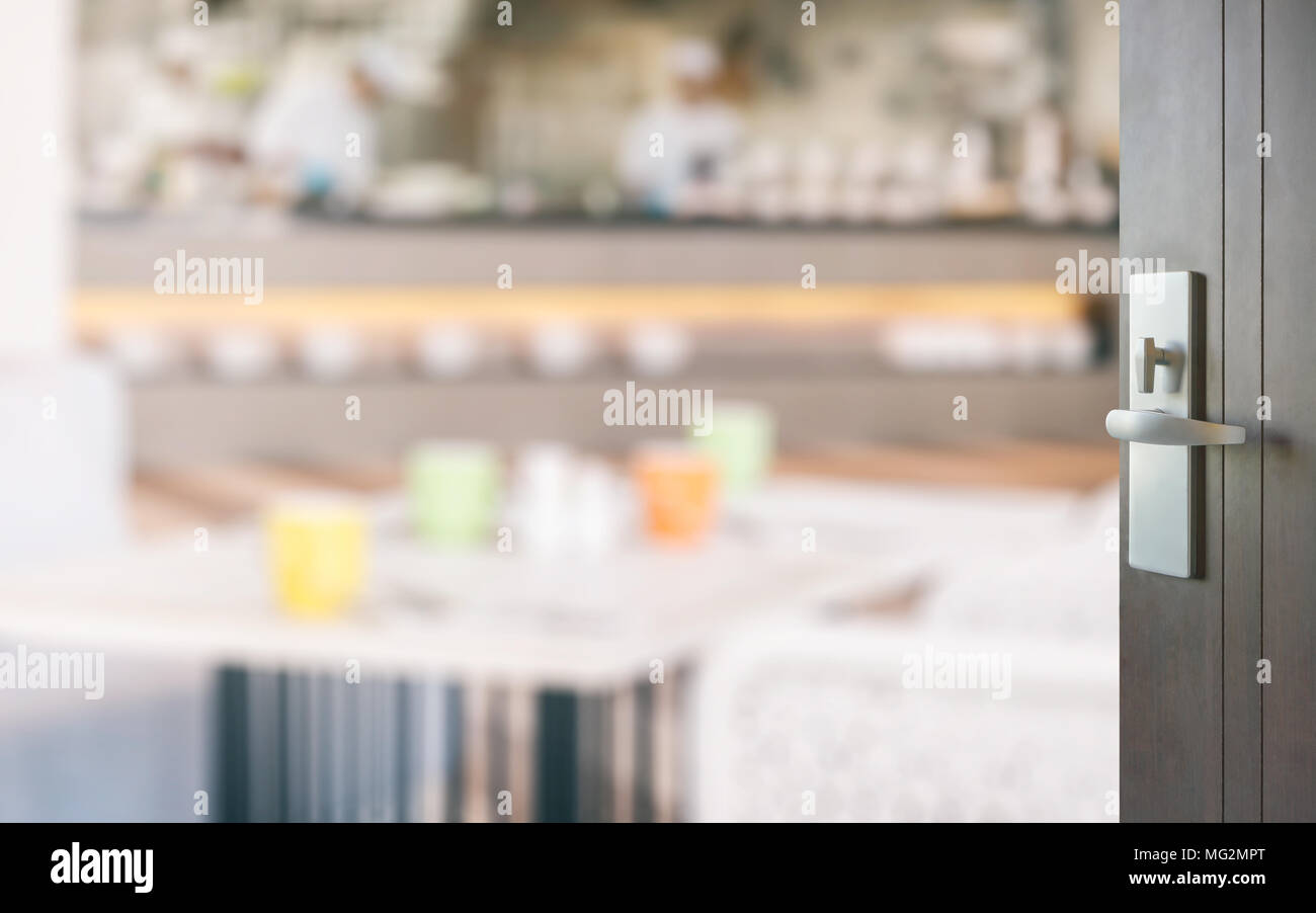 opened wooden door to restaurant interior with colorful tables set for ...