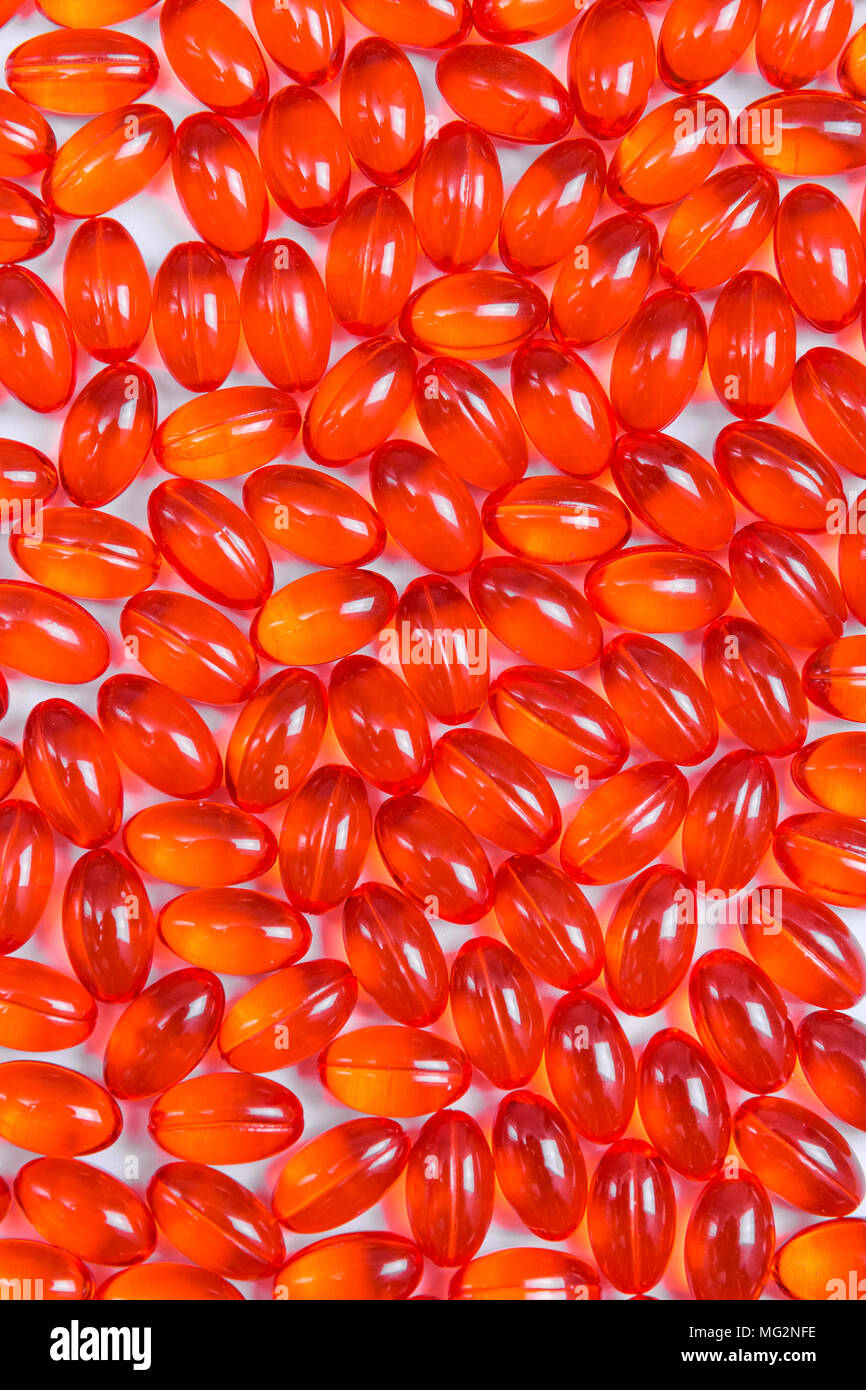 Red shiny pills background. Capsules with medicine on white surface ...
