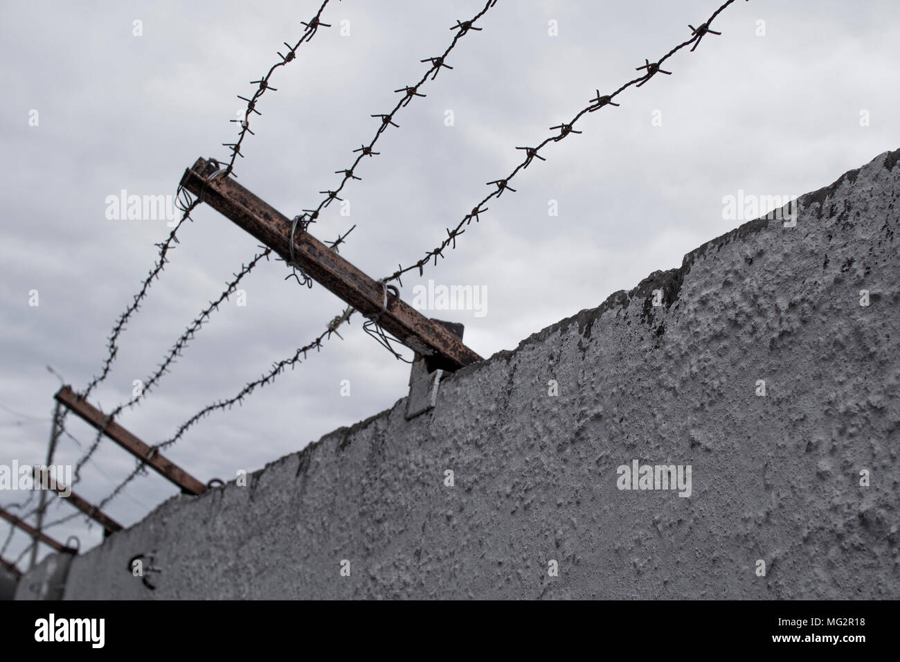 Concrete fence with barbed wire. Freedom, jail, prison, human rights ...
