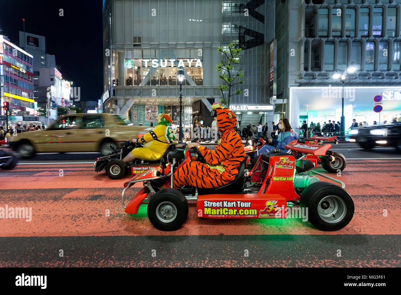 Western and Asian tourists enjoy riding Mari Cars go carts through ...