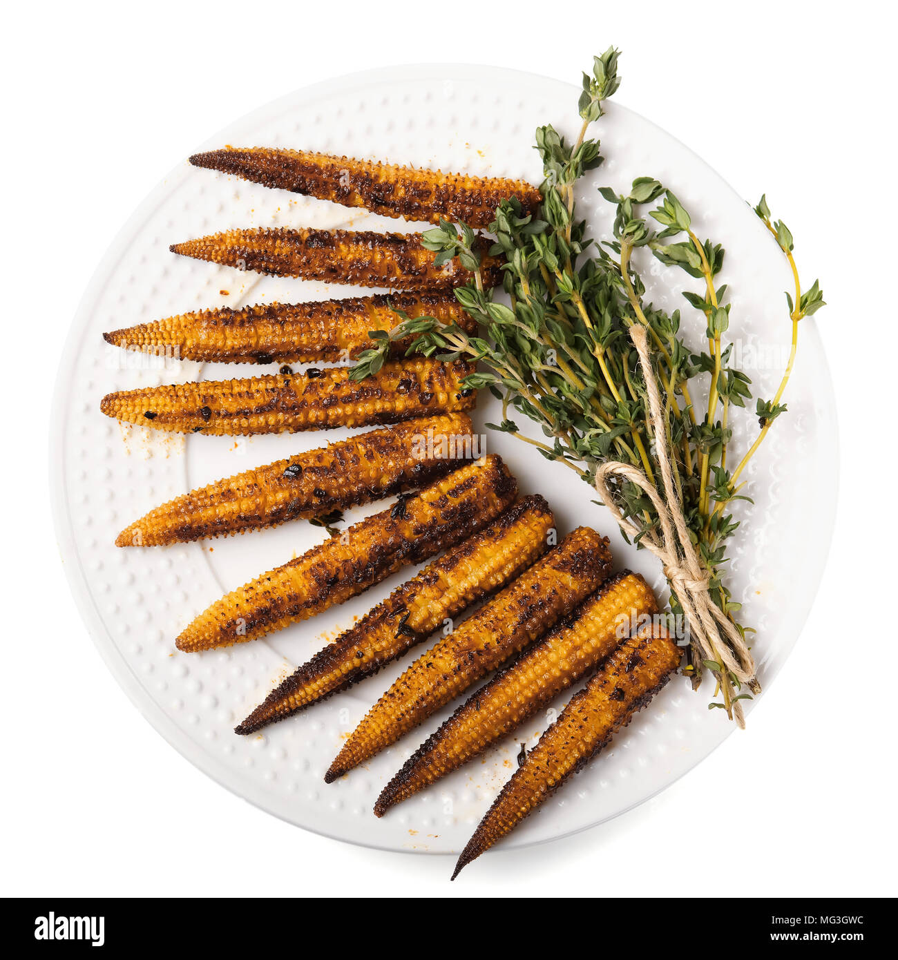 Several fried cobs of young corn with a bunch of thyme isolated on a ...