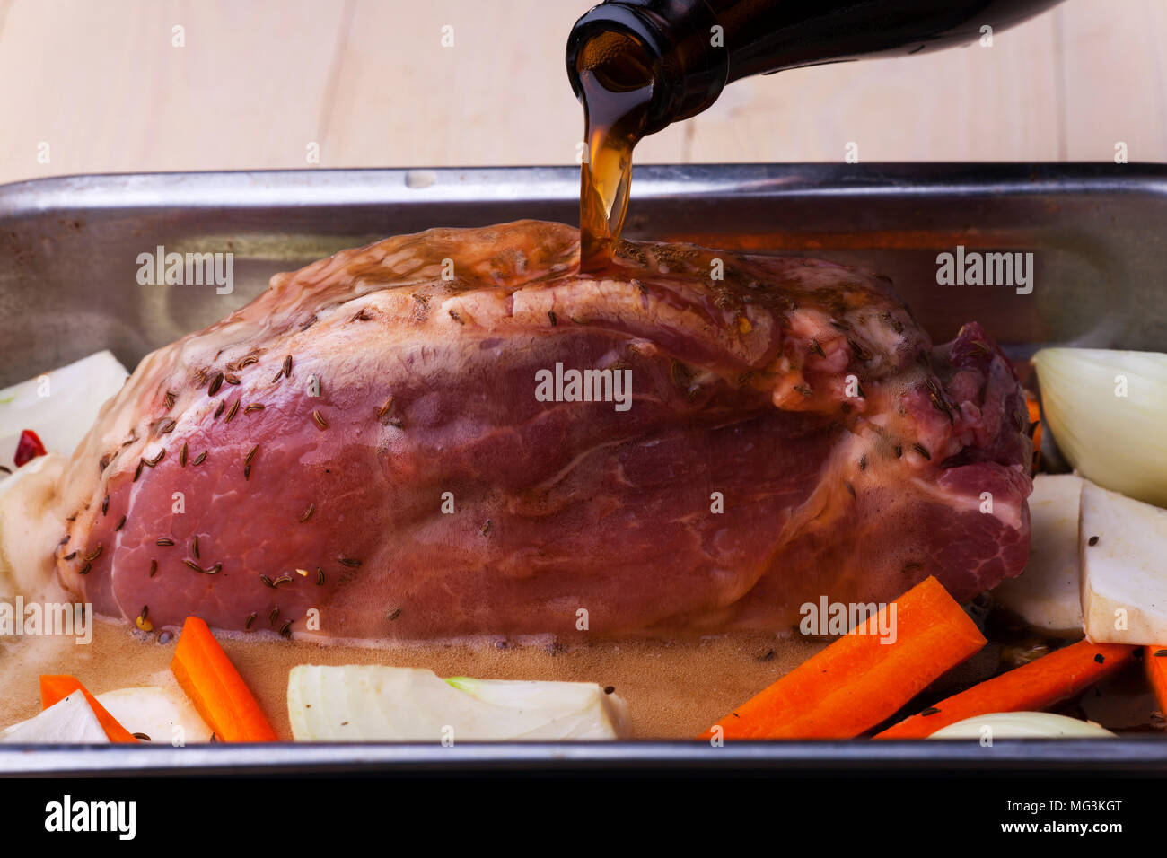 pouring beer over a roasted pork Stock Photo - Alamy