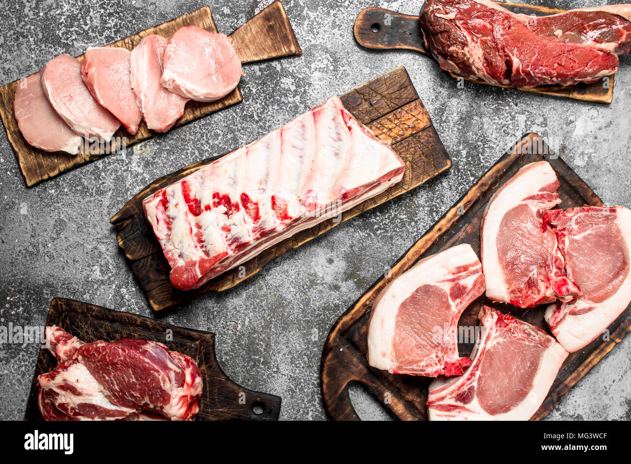 Different types of raw meat on the boards. On rustic background Stock ...