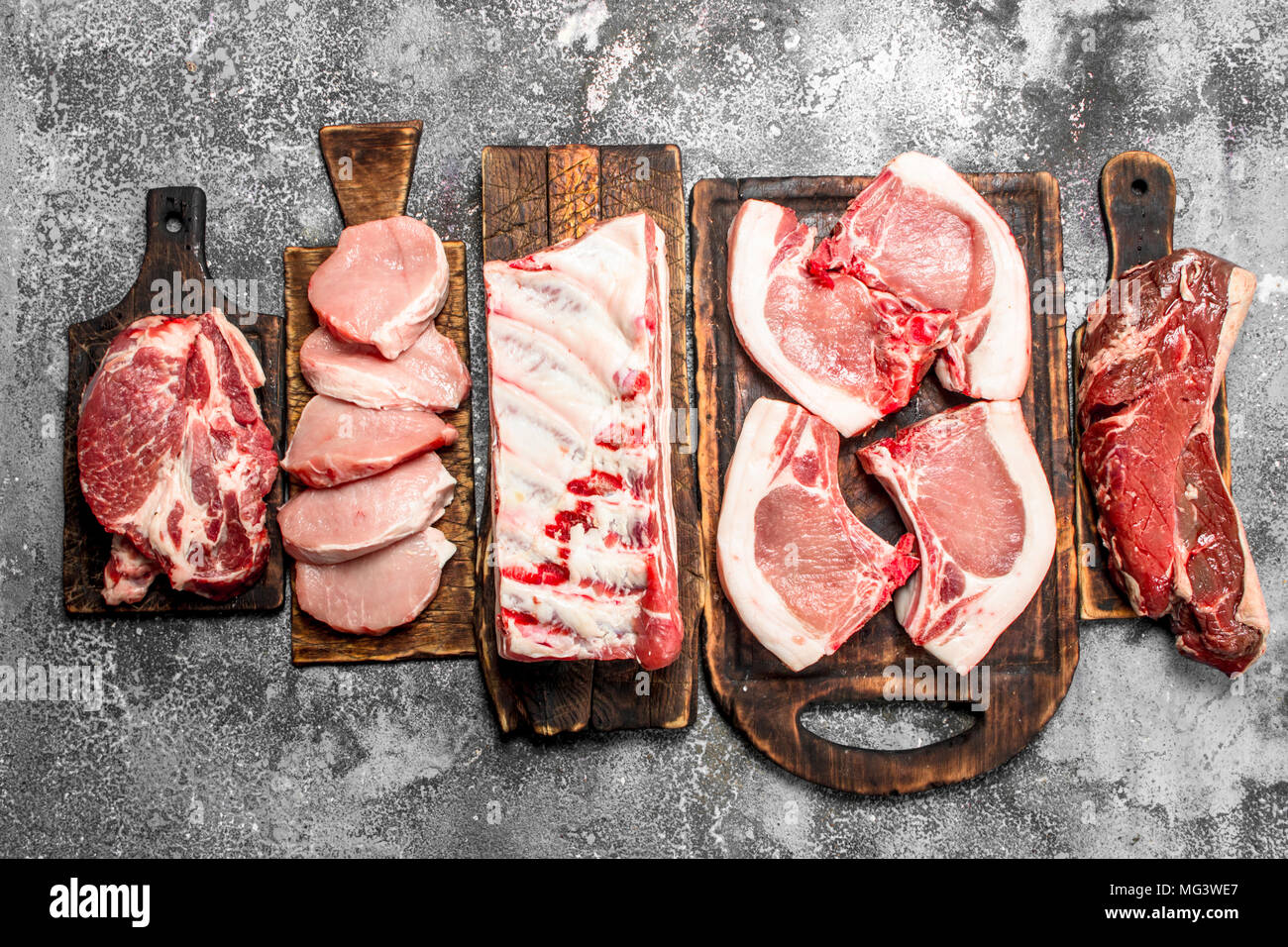 Different types of raw meat on the boards. On rustic background Stock ...
