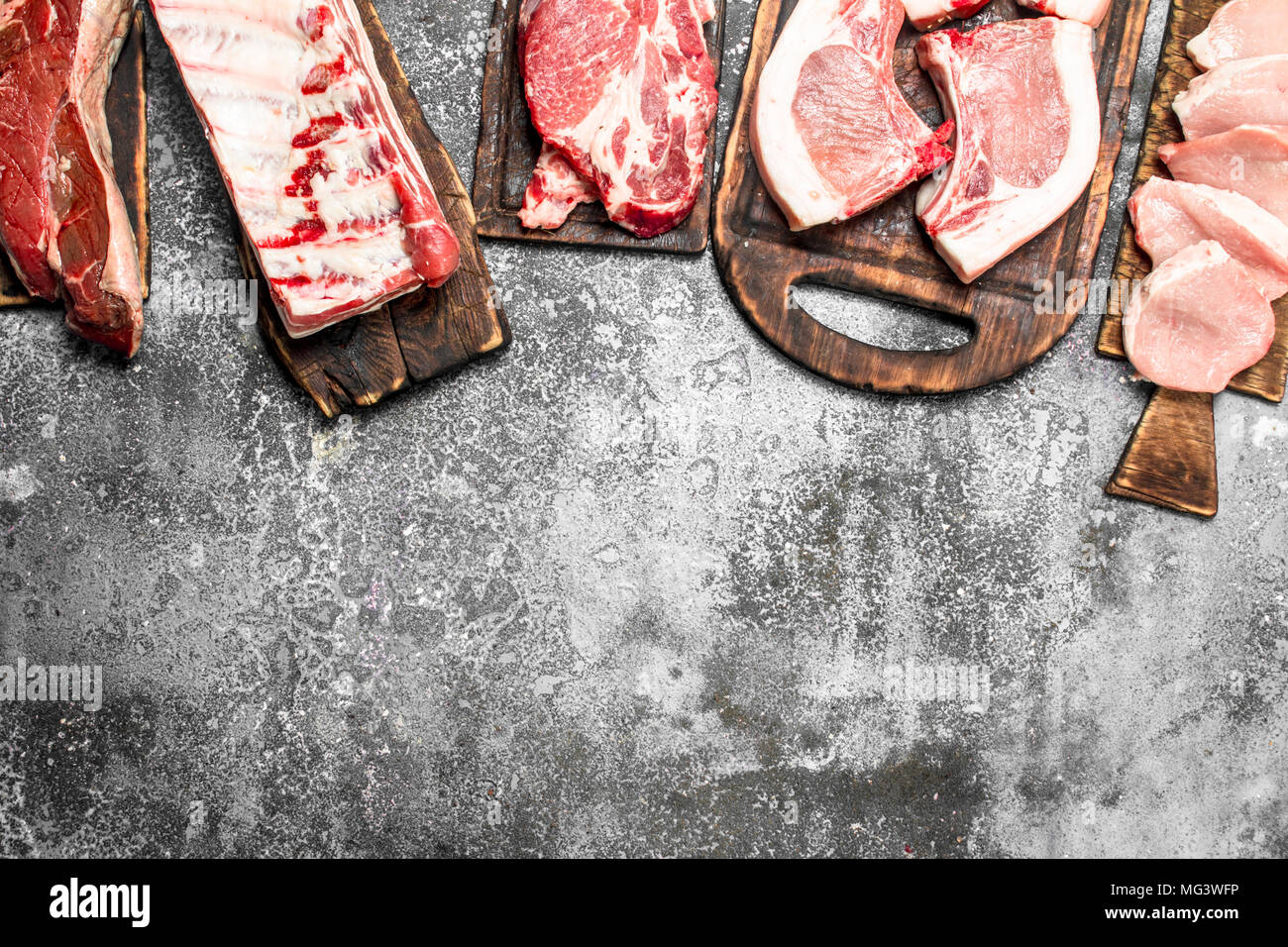 Different types of raw meat on the boards. On rustic background Stock ...