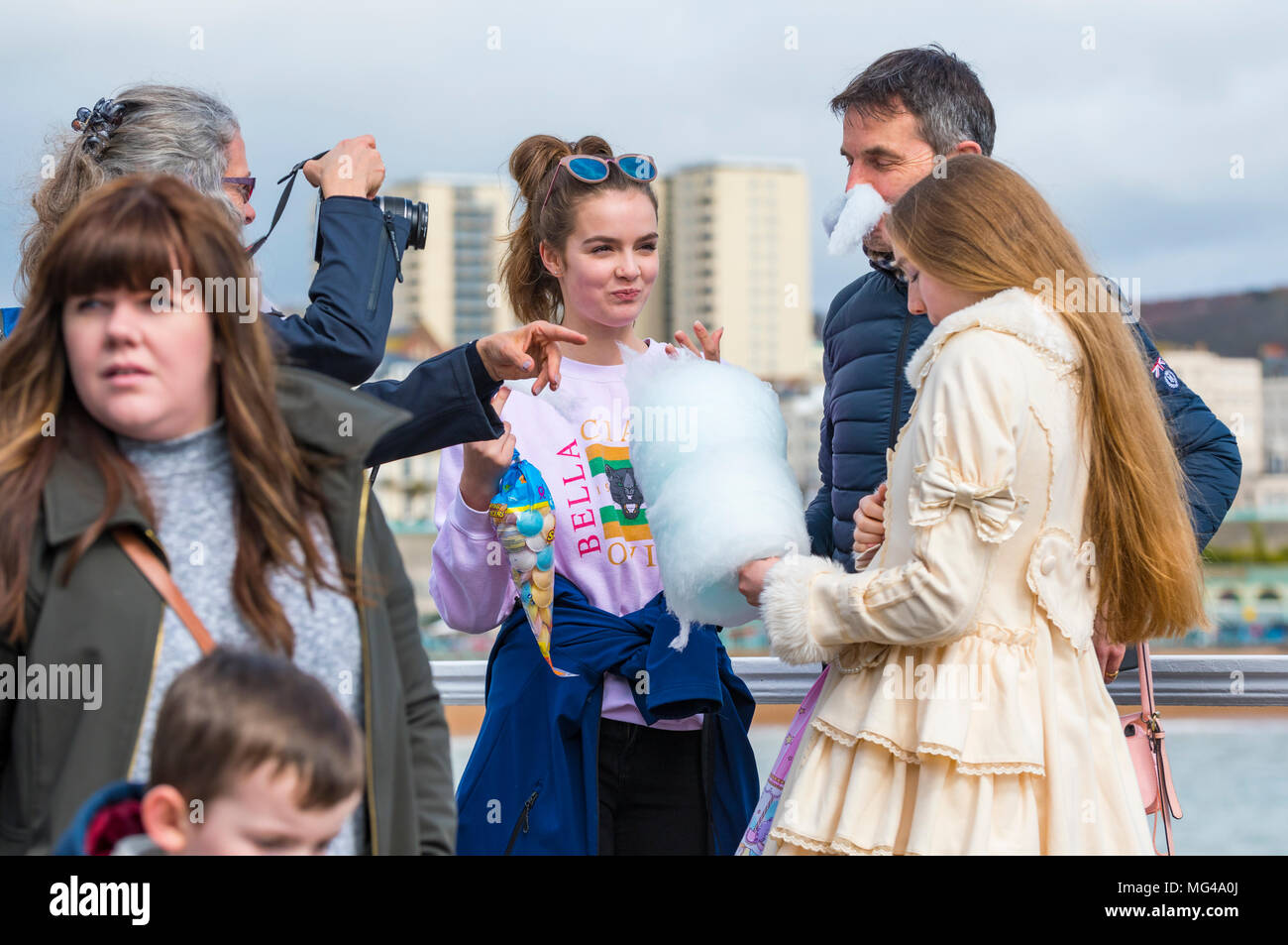 Family eating candyfloss (candy floss, cotton candy) by the seaside on ...