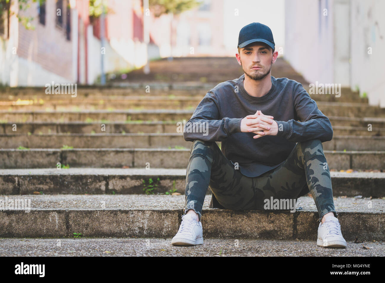 Young man sitting on stairs hi-res stock photography and images - Alamy