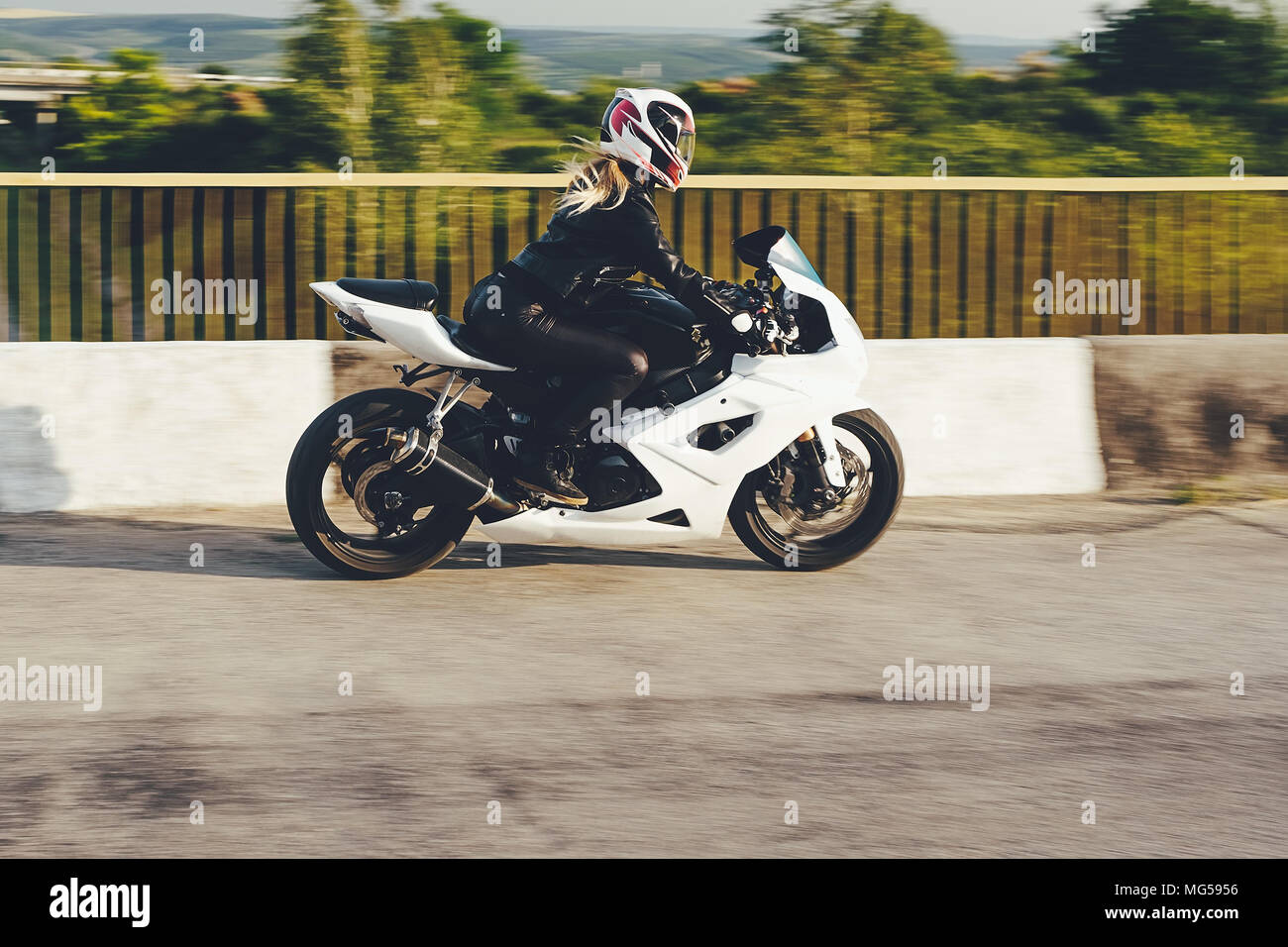 Woman biker driving a motorbike on a road Stock Photo - Alamy