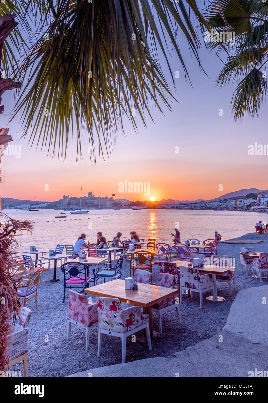 Unidentified people enjoy at beach cafe and Sunset view of Bodrum ...