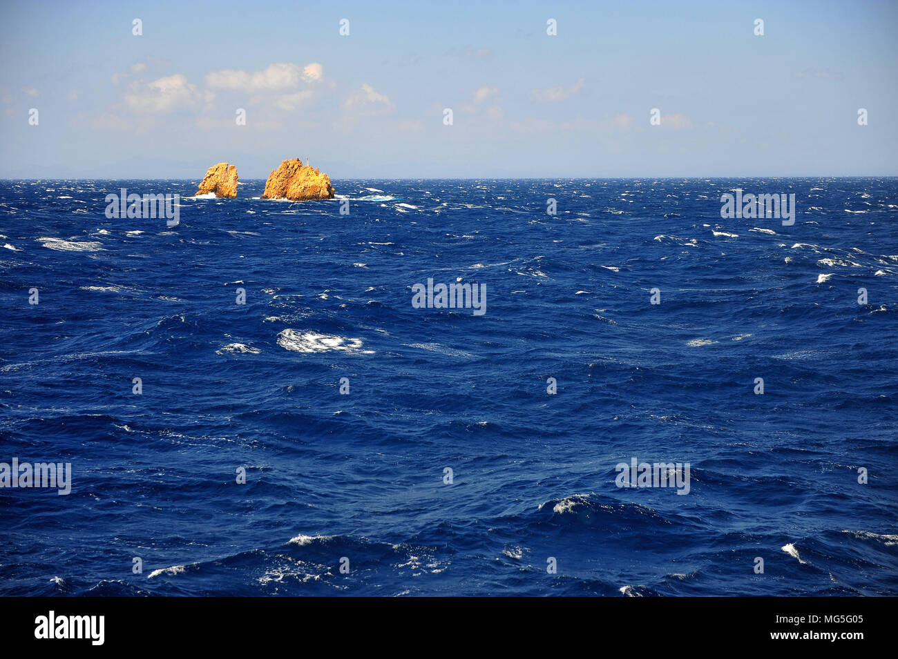 Two rocks in the deep blue sea background Stock Photo - Alamy