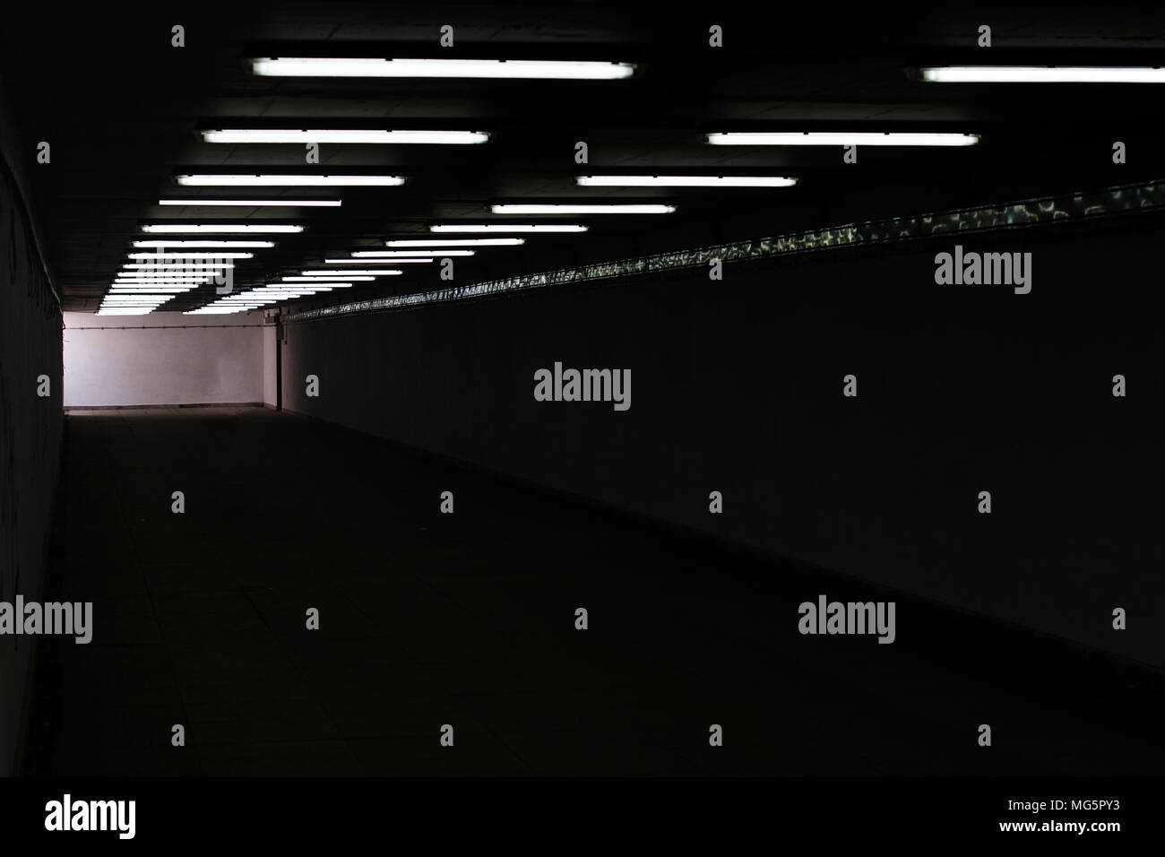 perspective view of dark underground tunnel with tubular neon lights ...