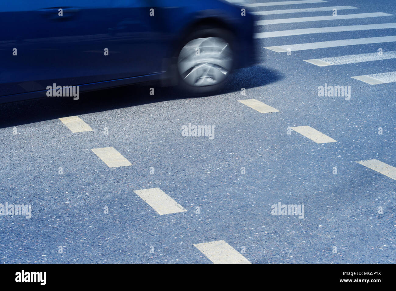 horizontal closeup of black car with motion blur near a pedestrian road ...