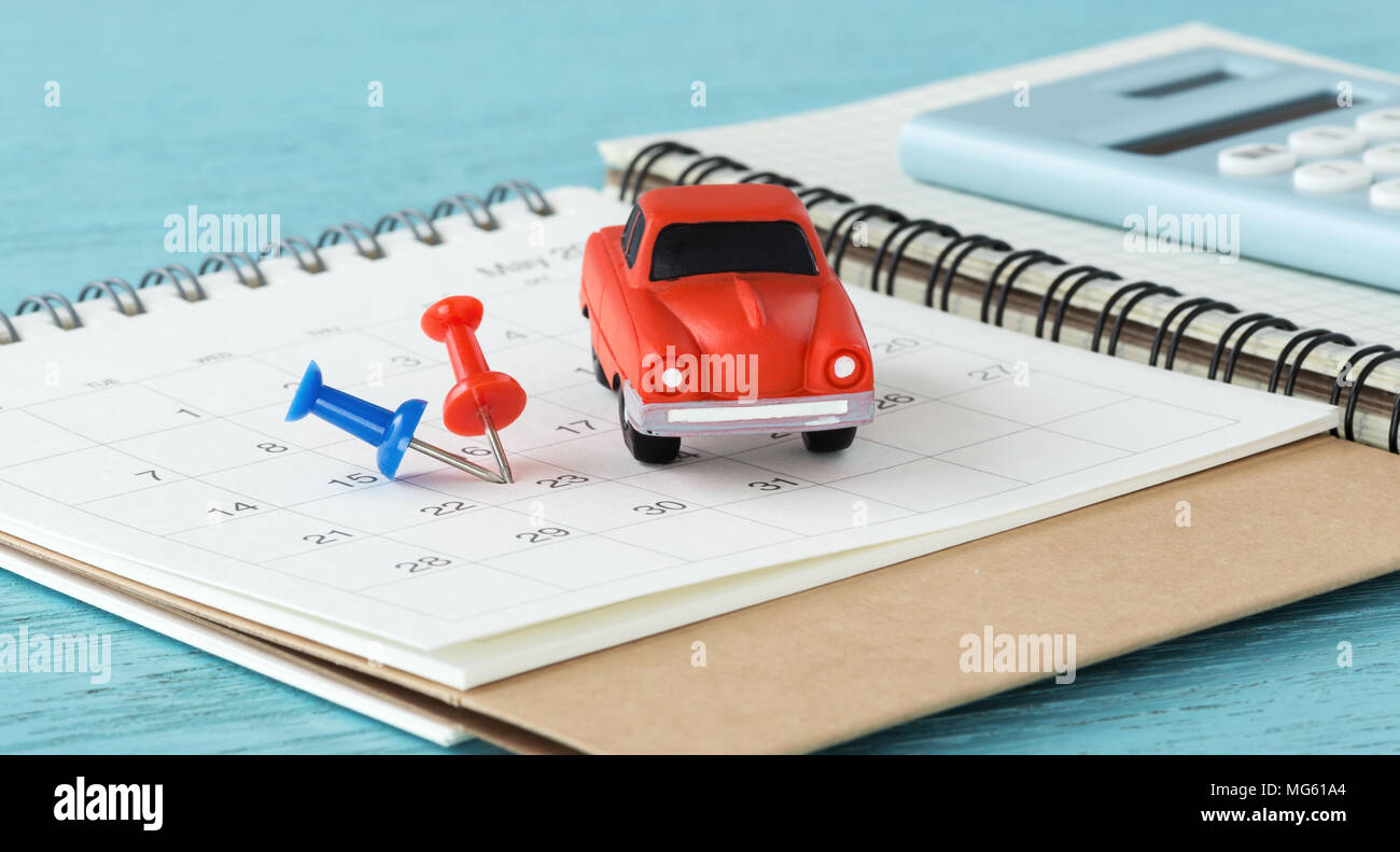 Toy car and pins on calendar with calculator Stock Photo - Alamy