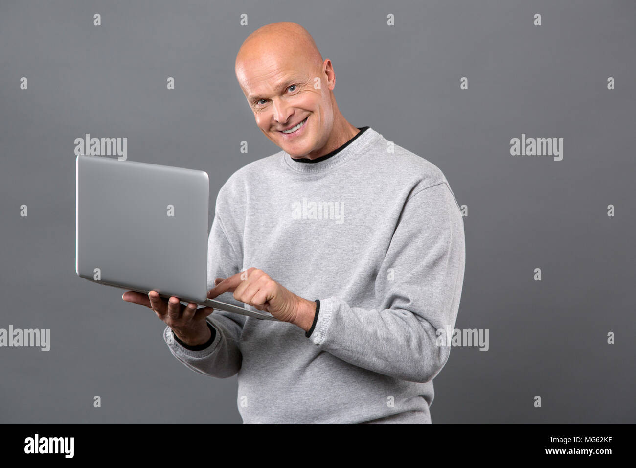 Cheerful positive man using a laptop Stock Photo - Alamy